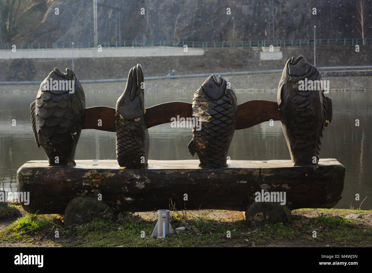 Wooden bench with fish sculptures Stock Photo - Alamy