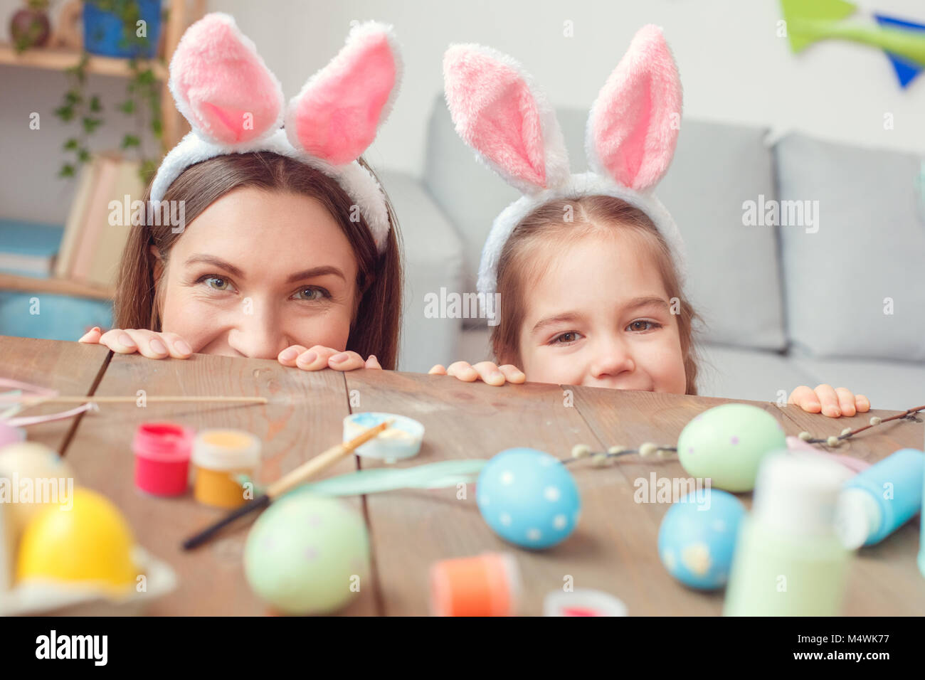 Mother and daughter together in bunny ears at home easter celebration ...