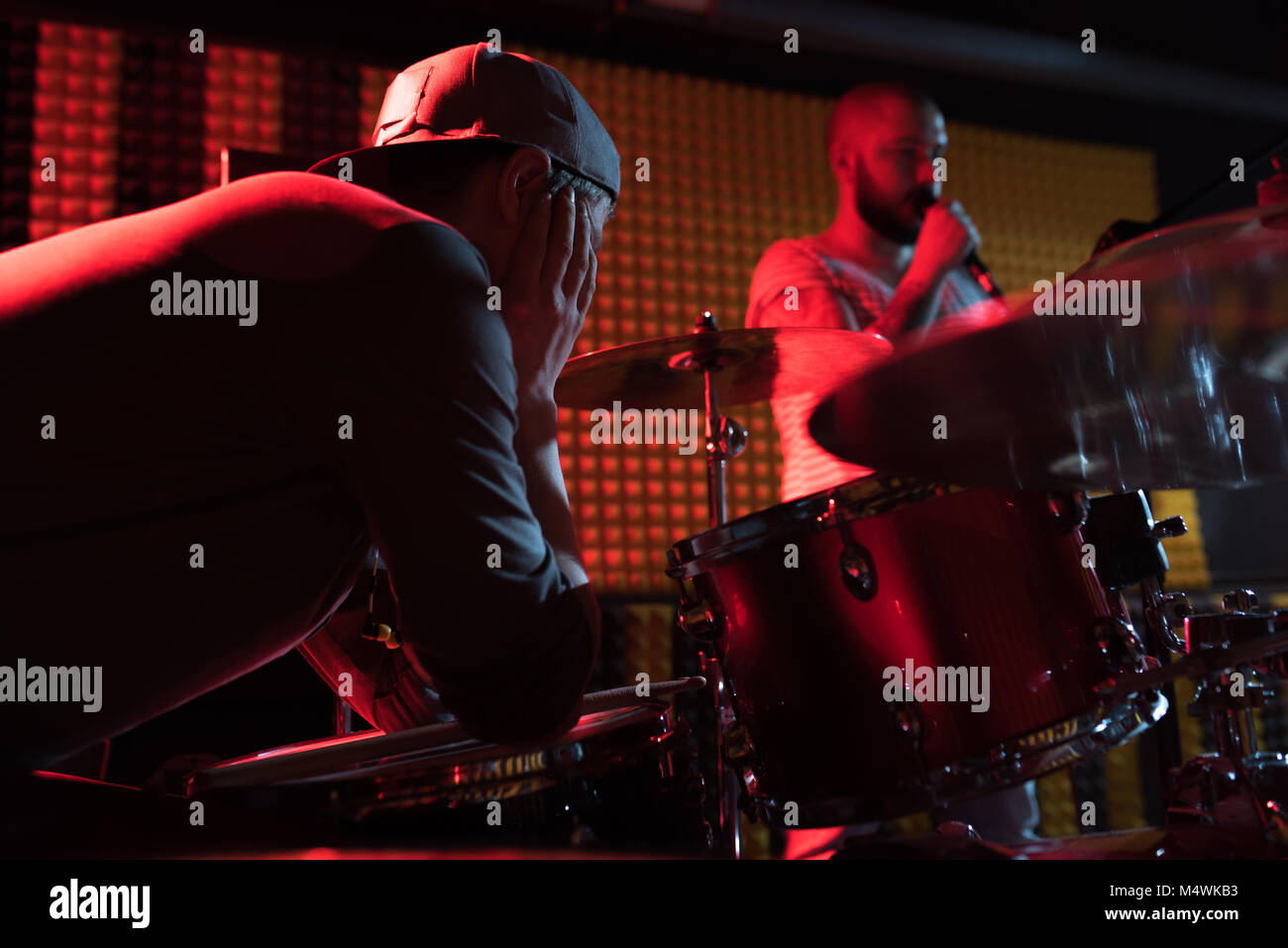 Side view portrait of tired drummer taking break during band rehearsal ...