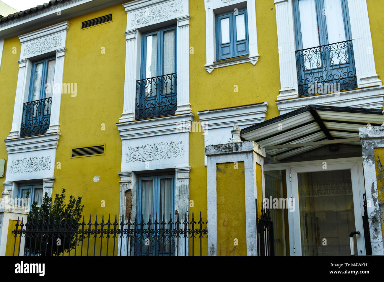 Beautiful old yellow house with blue windows Stock Photo - Alamy
