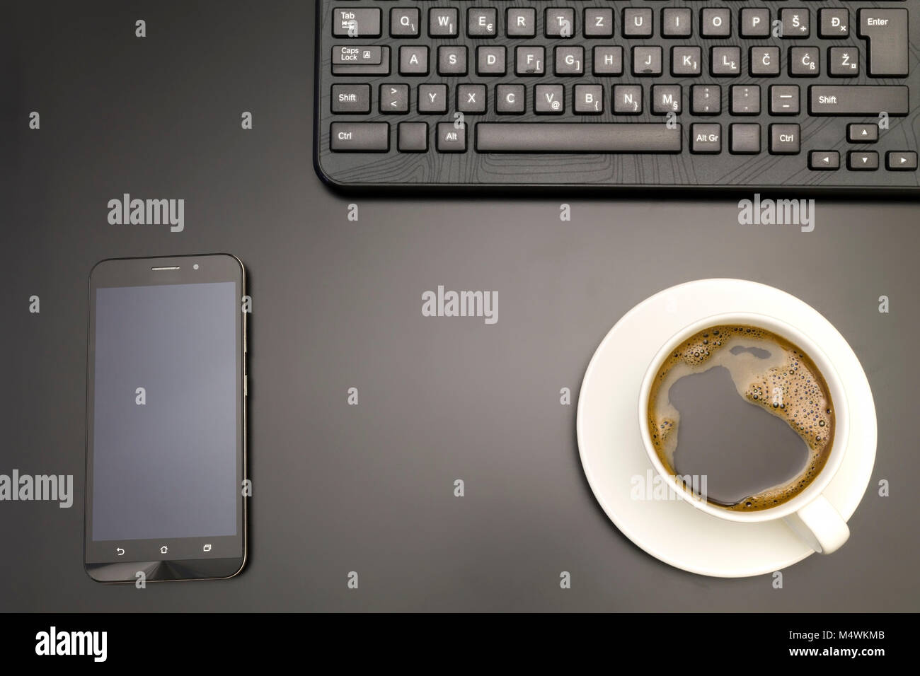 Office work space with phone,coffee and keyboard Stock Photo - Alamy