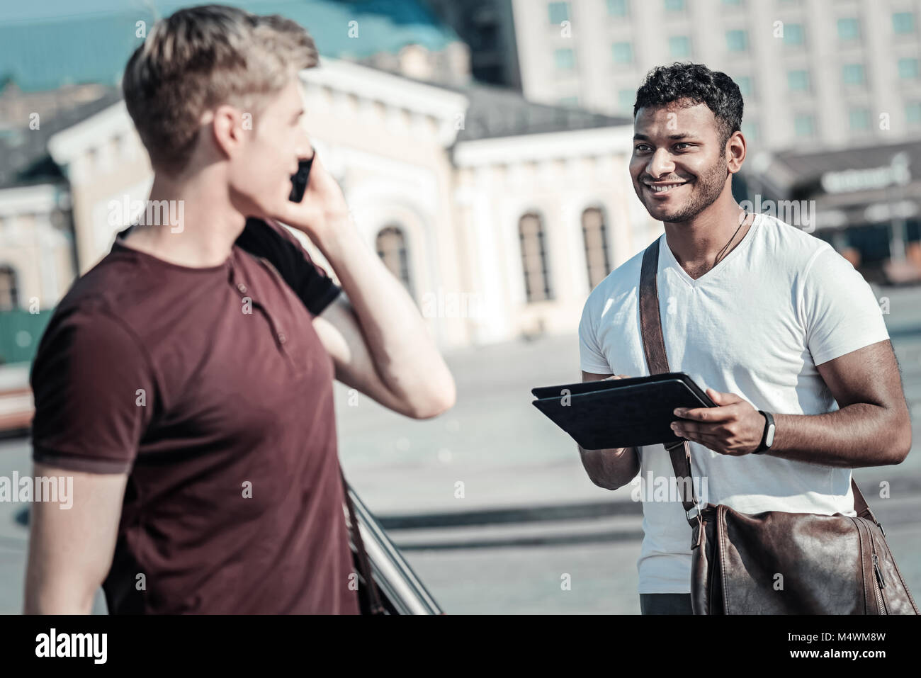 Happy joyful man turning to his friend Stock Photo - Alamy