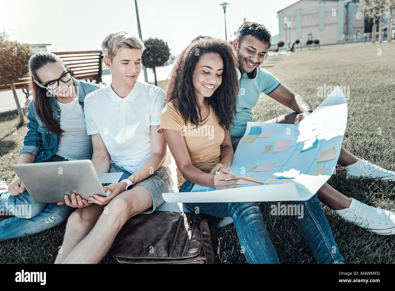 Joyful happy students sitting on the grass Stock Photo - Alamy