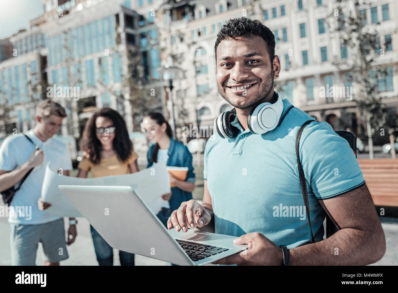 Cheerful happy student holding his laptop Stock Photo - Alamy