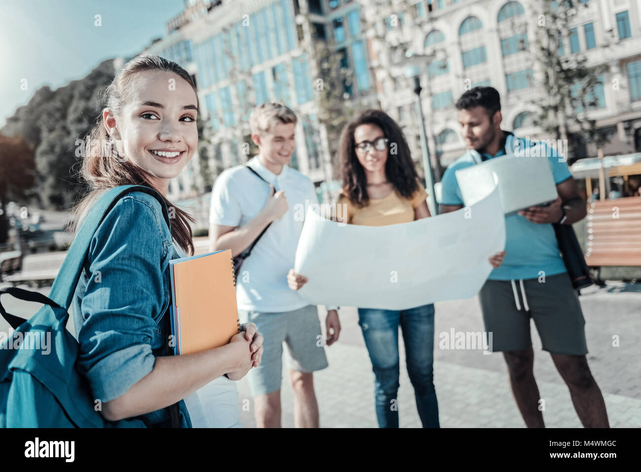 Positive beautiful woman approaching her friends Stock Photo - Alamy