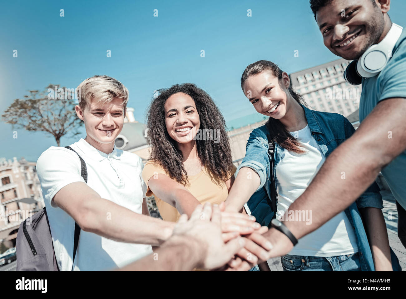 Positive young students holding their hands together Stock Photo - Alamy
