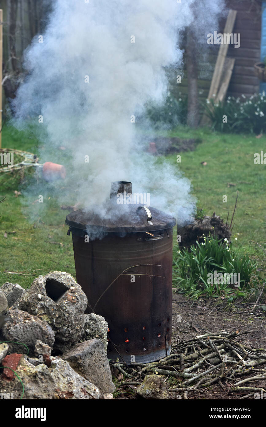 A garden incinerator or bonfire smoking heavily and polluting the local ...