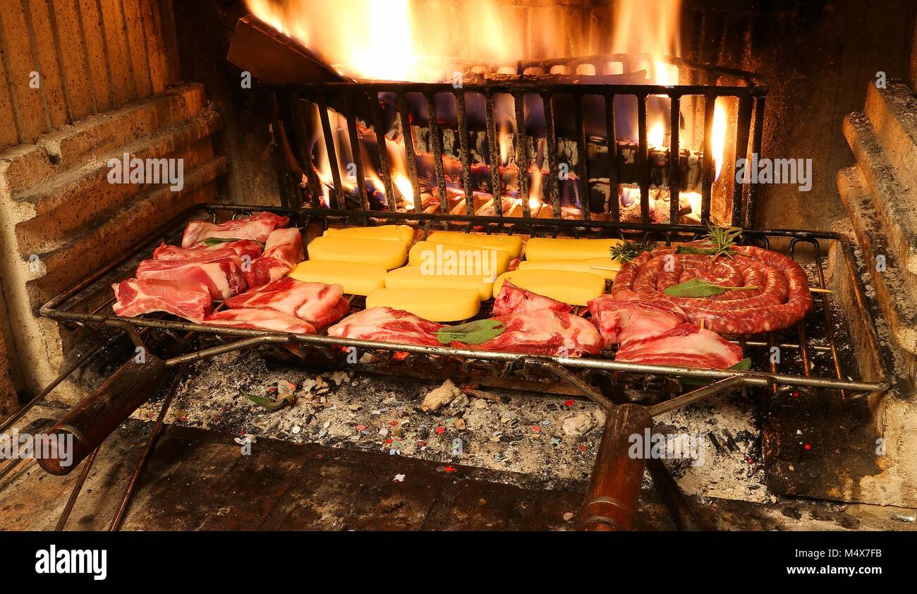 raw meat cooking in the fireplace with a warm fire Stock Photo - Alamy