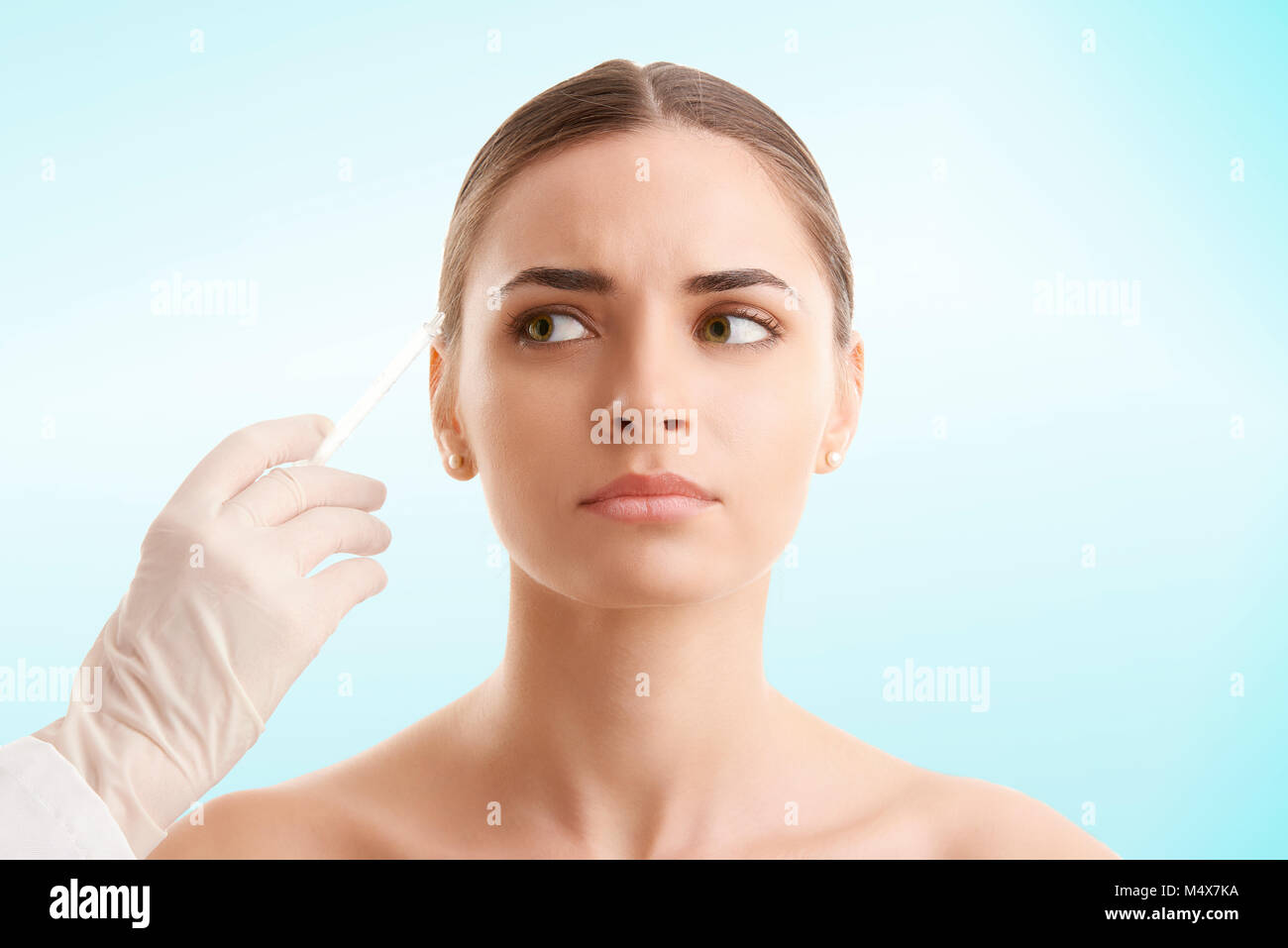 Portrait of an attractive young woman receiving botox treatment ...