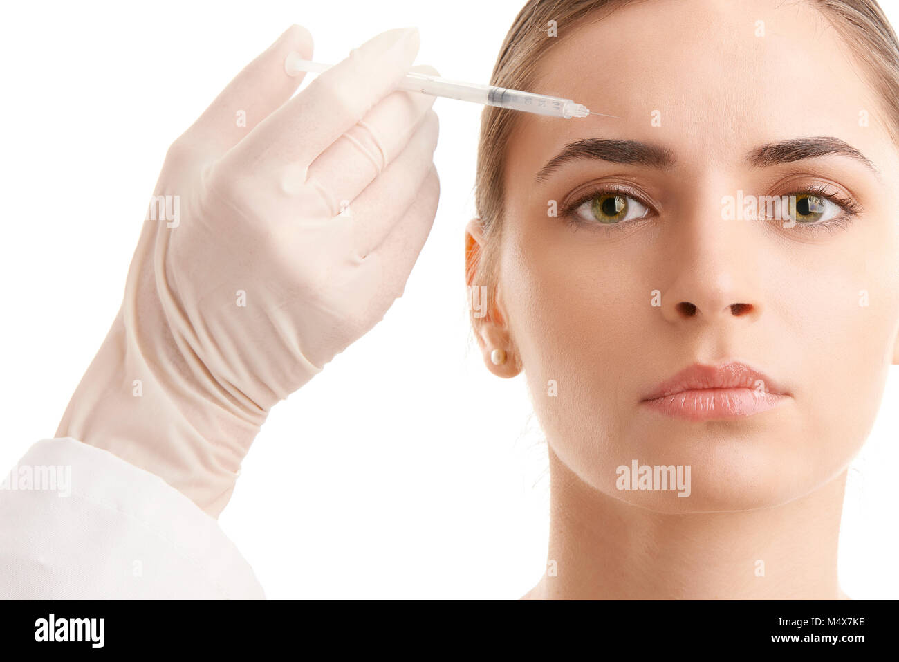 Portrait of an attractive young woman receiving botox treatment ...
