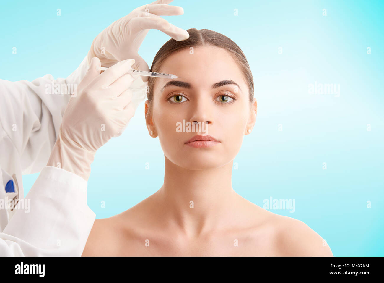 Portrait of an attractive young woman receiving botox treatment ...