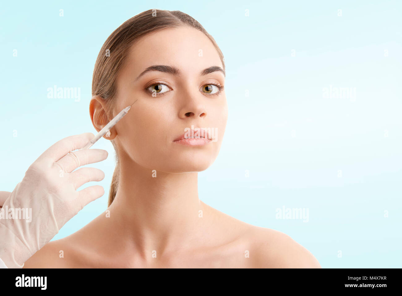 Portrait of an attractive young woman receiving botox treatment ...