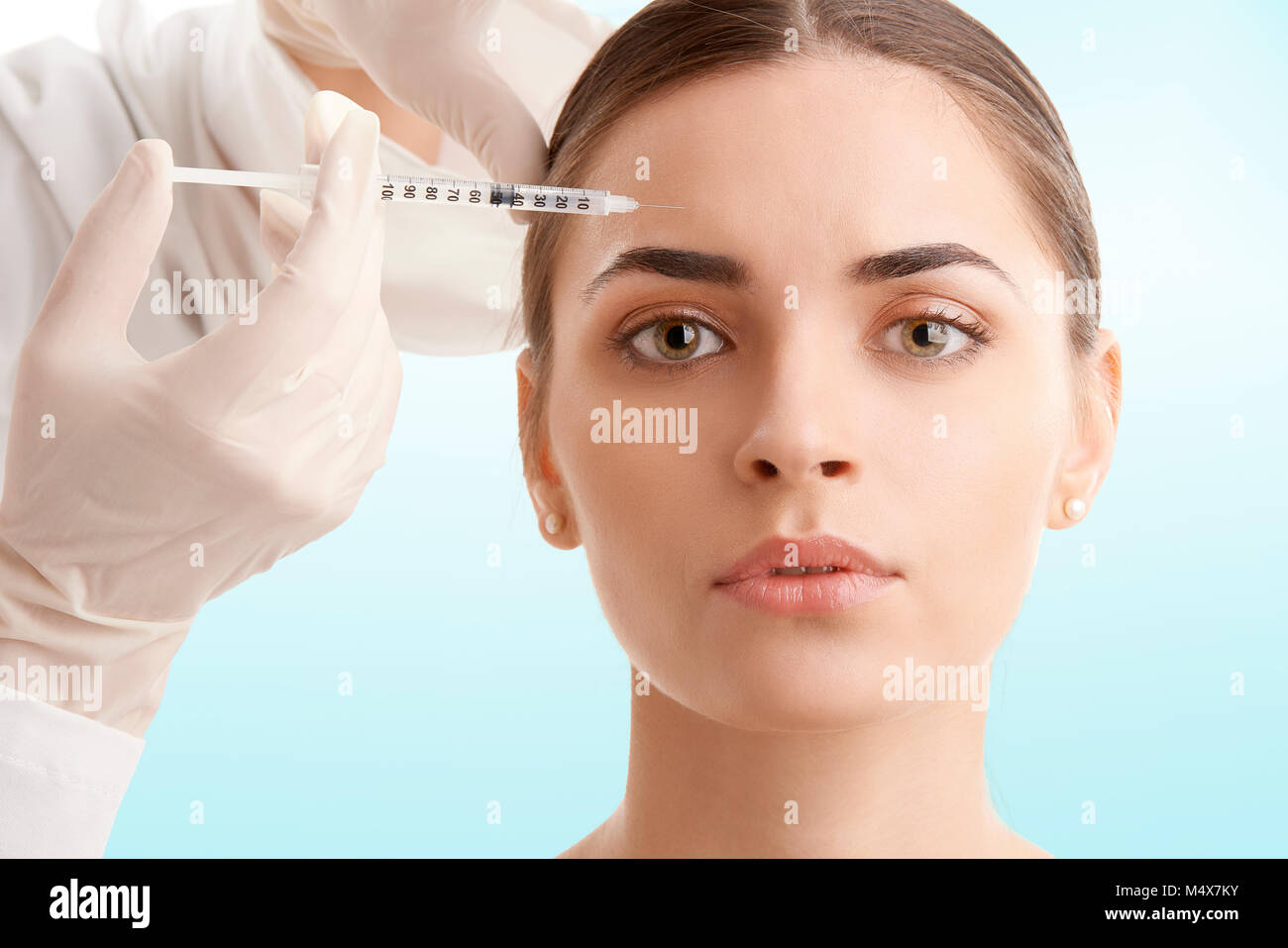 Portrait of an attractive young woman receiving botox treatment ...