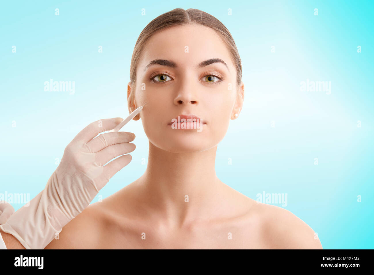 Portrait of an attractive young woman receiving botox treatment ...