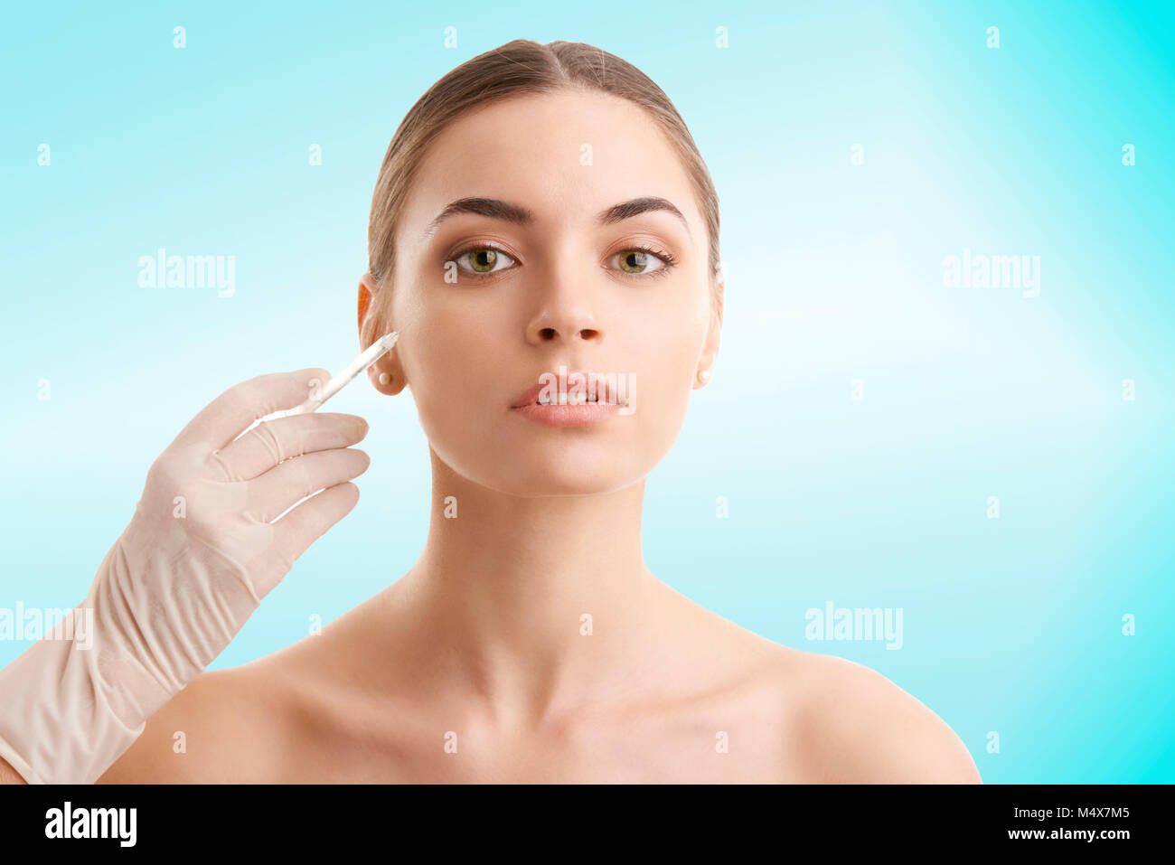 Portrait of an attractive young woman receiving botox treatment ...