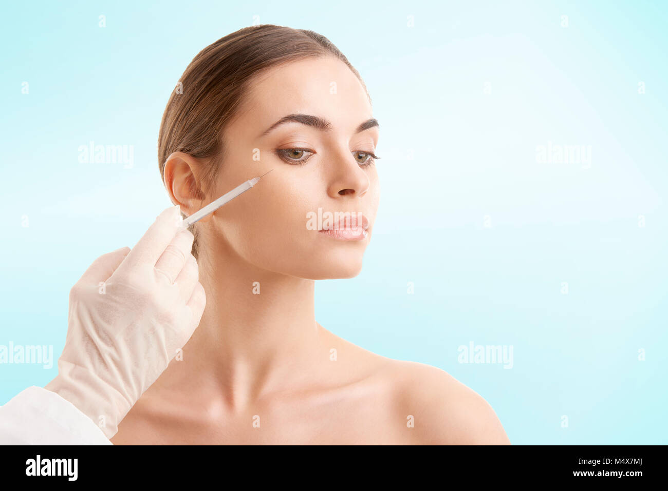 Portrait of an attractive young woman receiving botox treatment ...