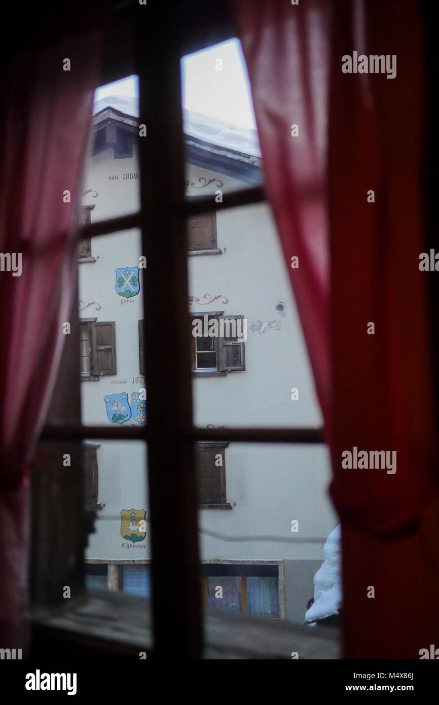 Traditional swiss village house seen through a window, Evolene, Valais ...