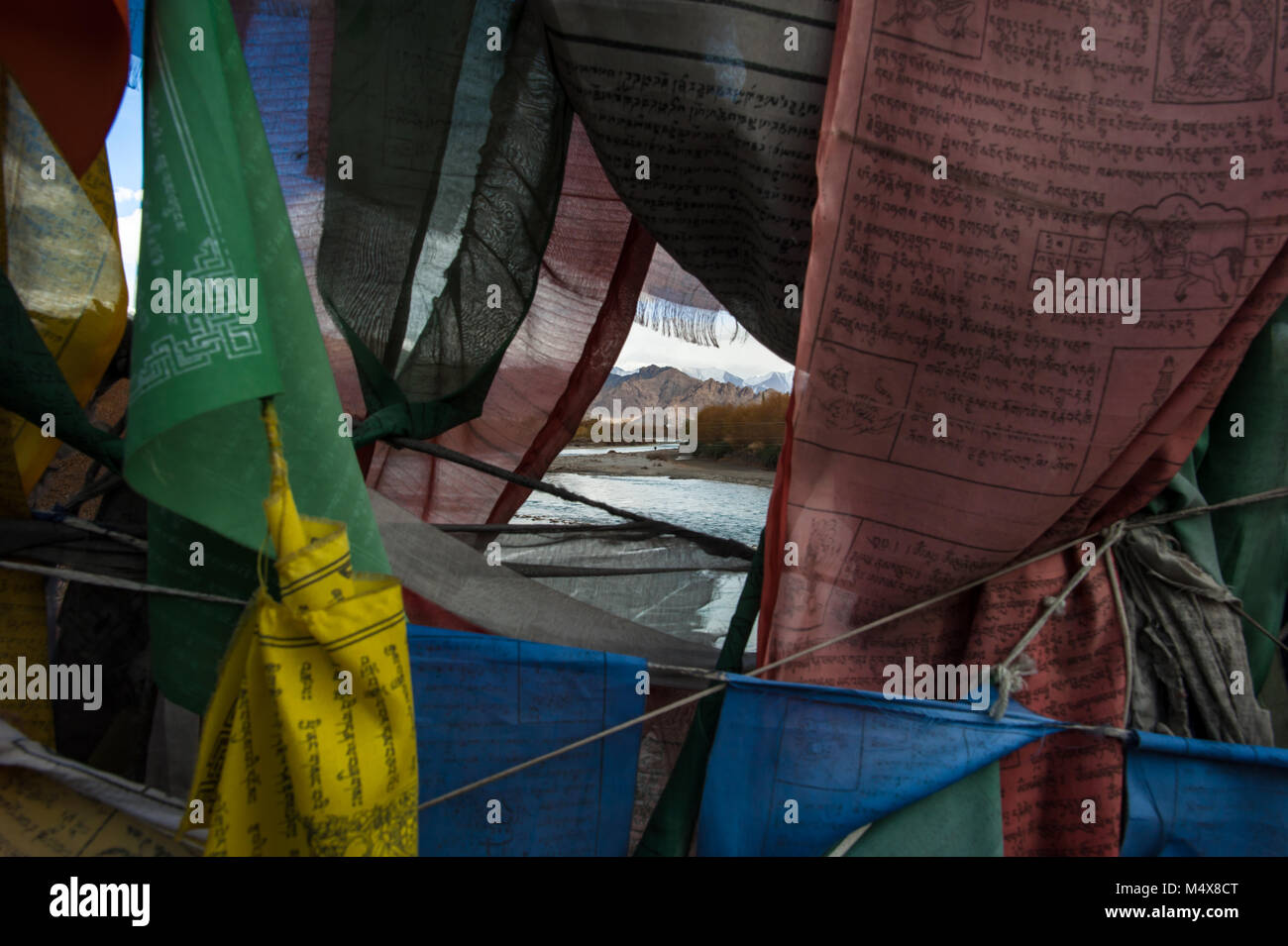 An unusual view of the River Indus, looking through prayer flags and ...