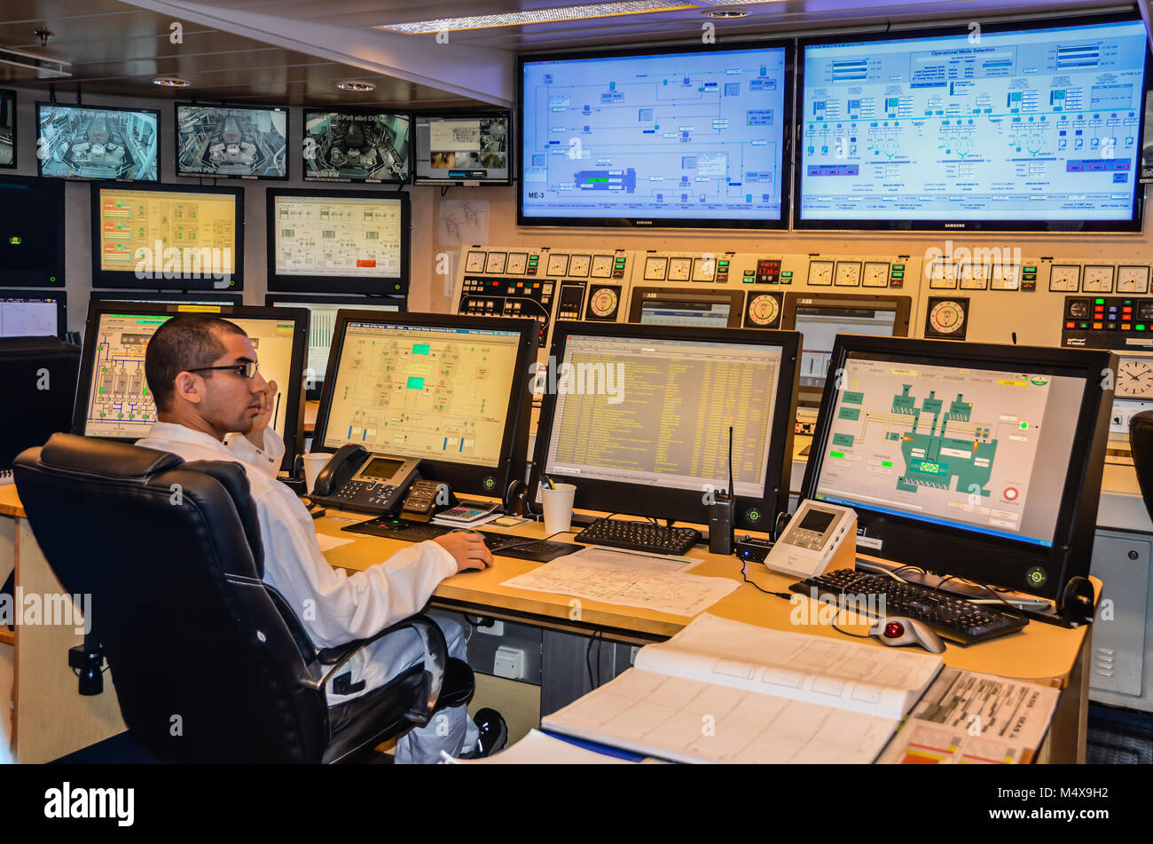 Man watches over large computer screens controlling major functions of ...