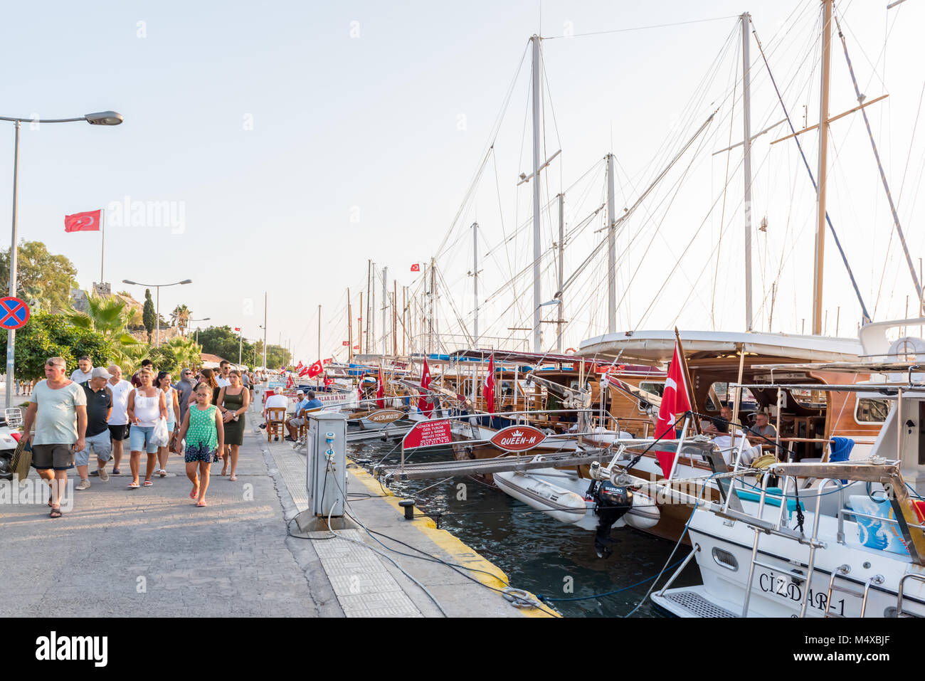 Unidentified people walk along shore in Bodrum with blue sky.Bodrum ...