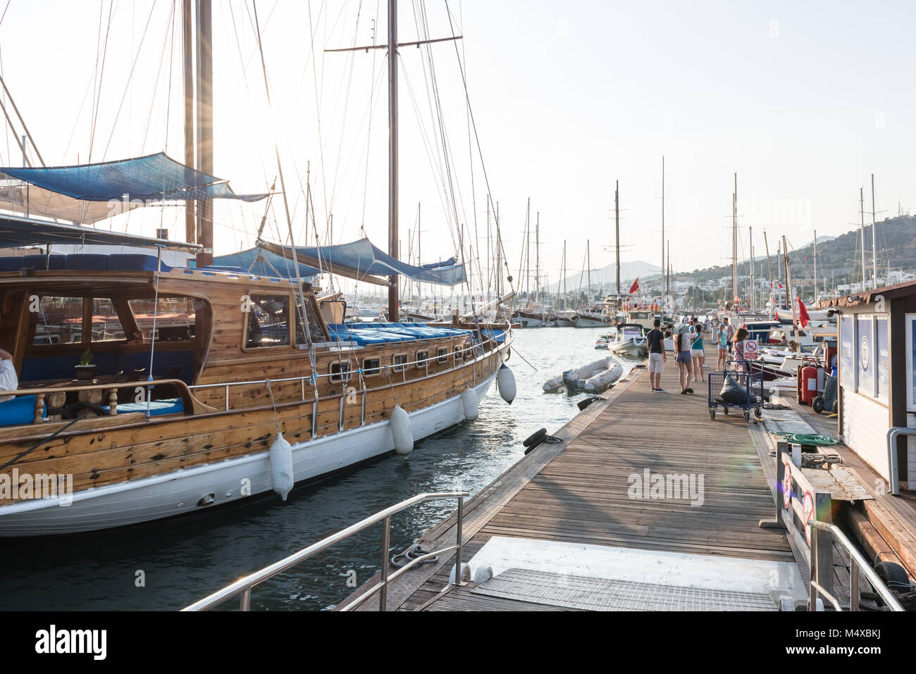 Unidentified people walk along shore in Bodrum with blue sky.Bodrum ...