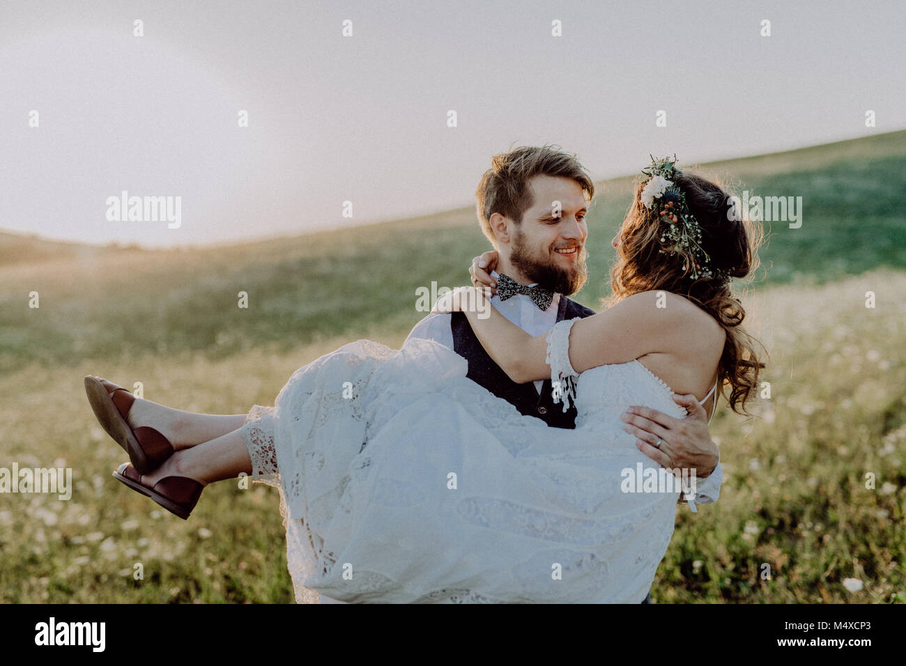 Beautiful young bride and groom outside in green nature at romantic ...