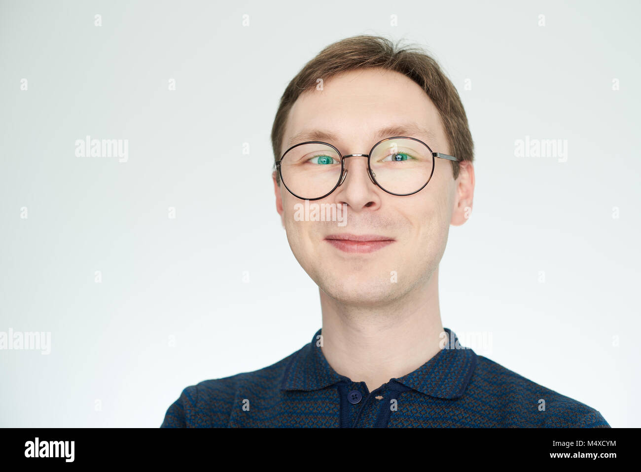 Cheerful positive looking young man in glasses isolated on white ...