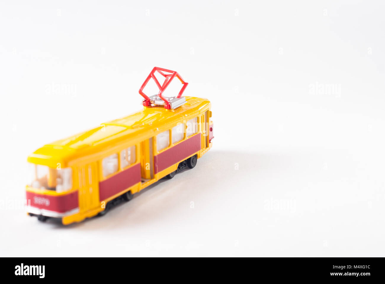 Toy tram in yellow on white background, public transport Stock Photo ...