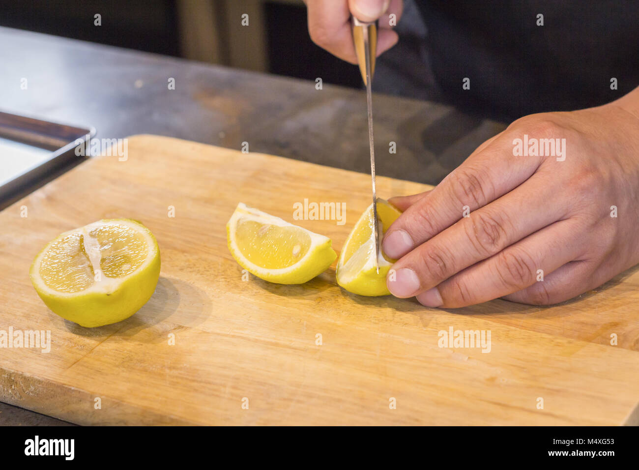 Chef slicing Lemon on wooden cutting board Stock Photo - Alamy
