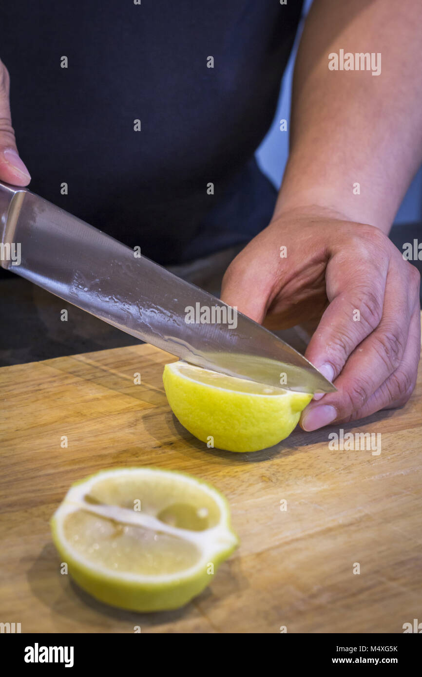 Chef slicing Lemon on wooden cutting board Stock Photo - Alamy