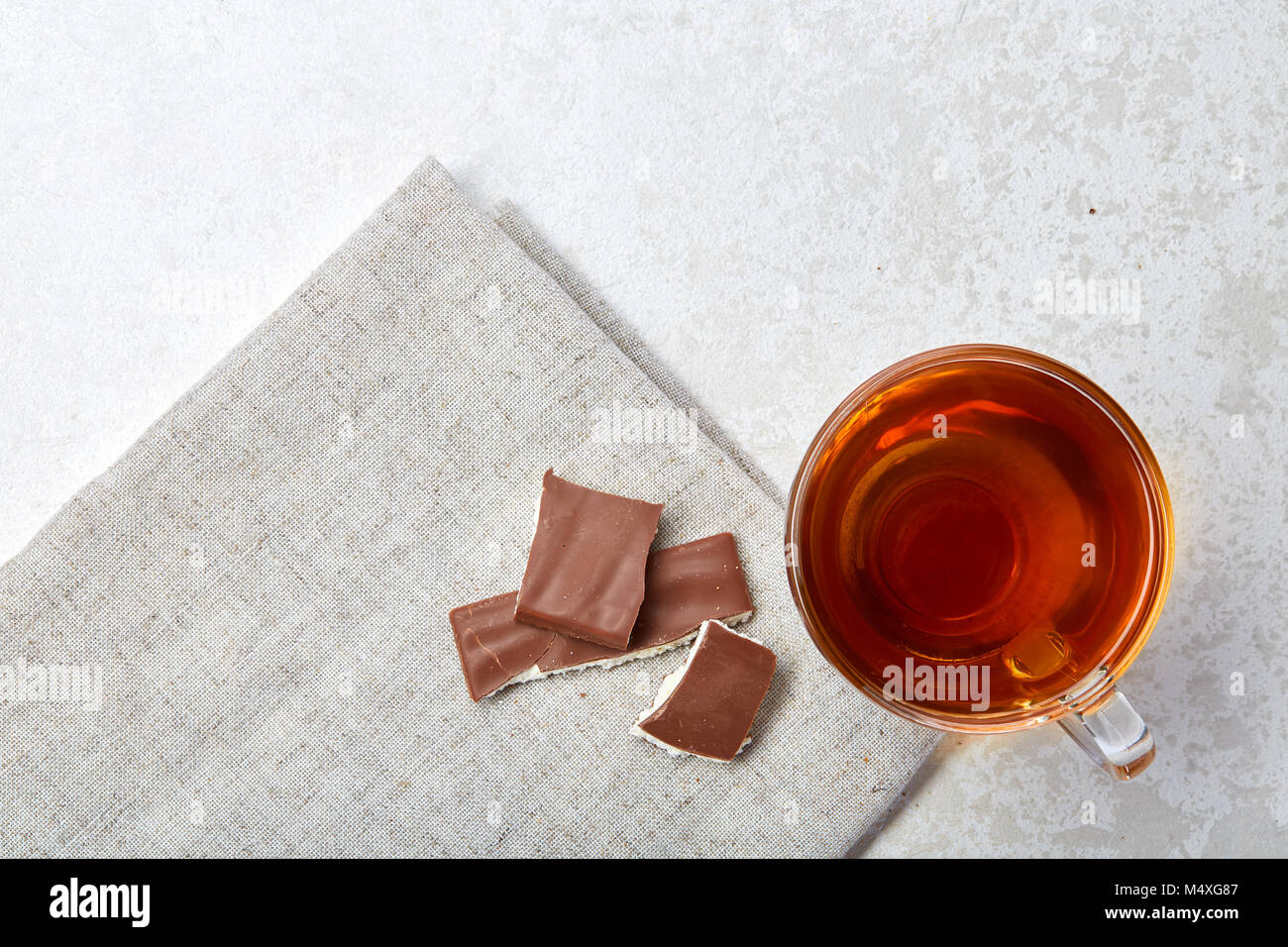 Some black or herbal tea in transparent cup with tasty chocolate on ...