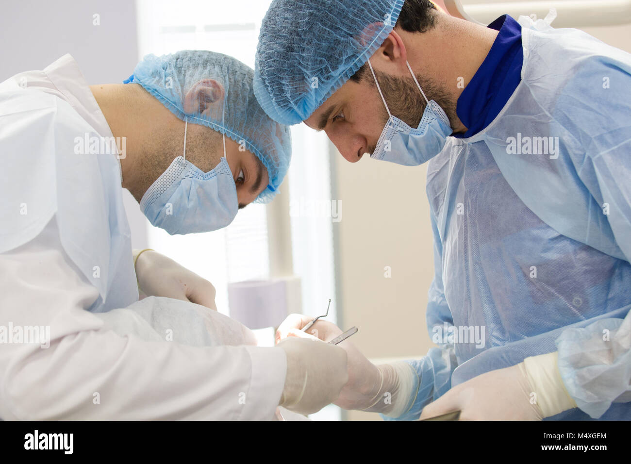Two surgeons in blue robes make operation in surgery room Stock Photo ...