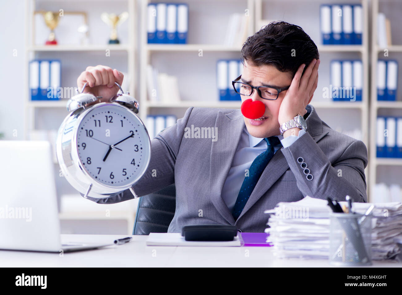 Clown businessman with alarm clock missing dieadline Stock Photo - Alamy