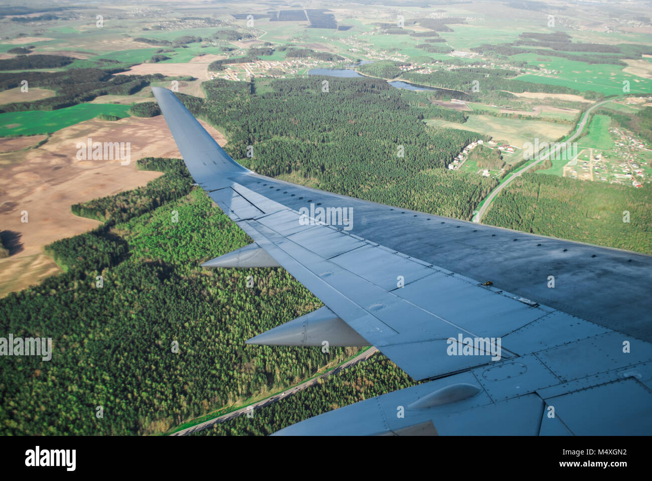 Fields and forests under the wing of the aircraft, the view from the ...