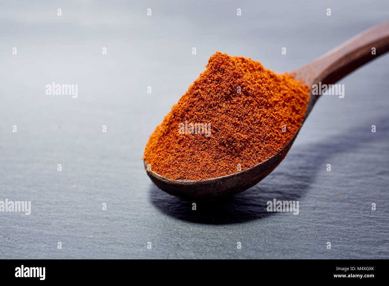 Shichimi pepper in Wooden spoon on black stone plate Stock Photo - Alamy