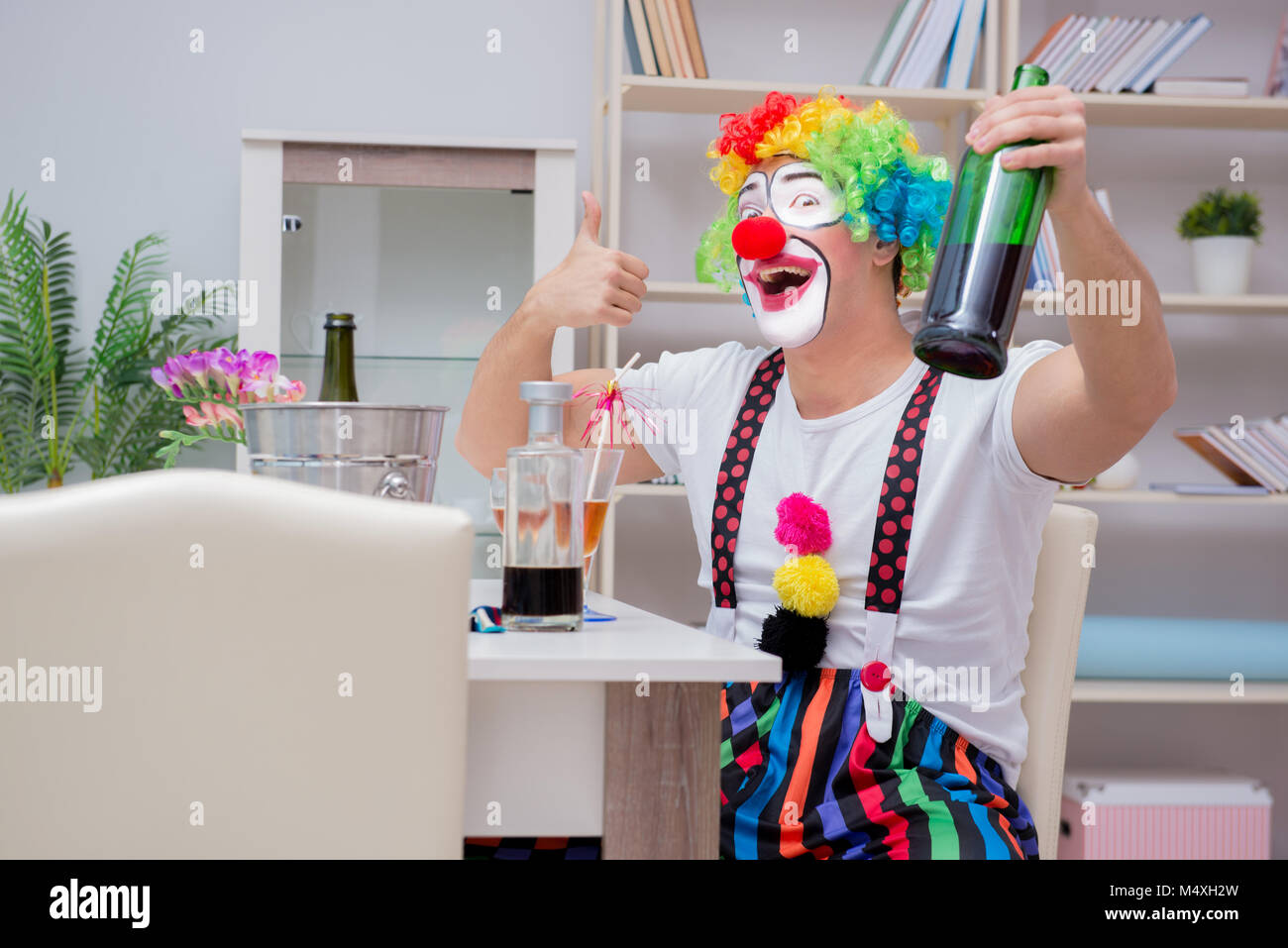 Drunk clown celebrating having a party at home Stock Photo - Alamy