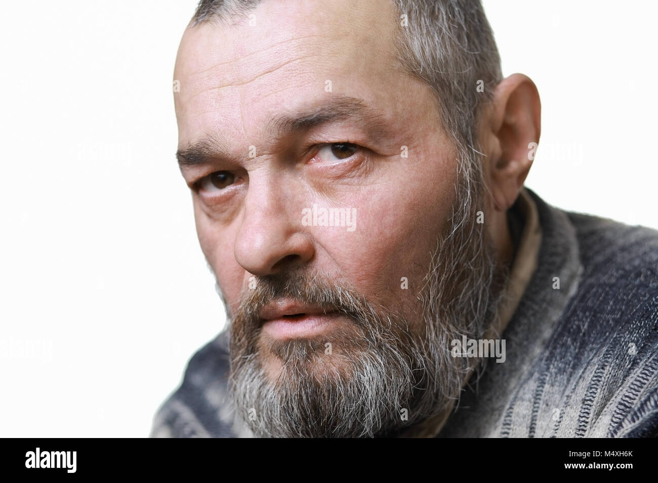 Real man with a beard looks at the camera on white background, close-up ...