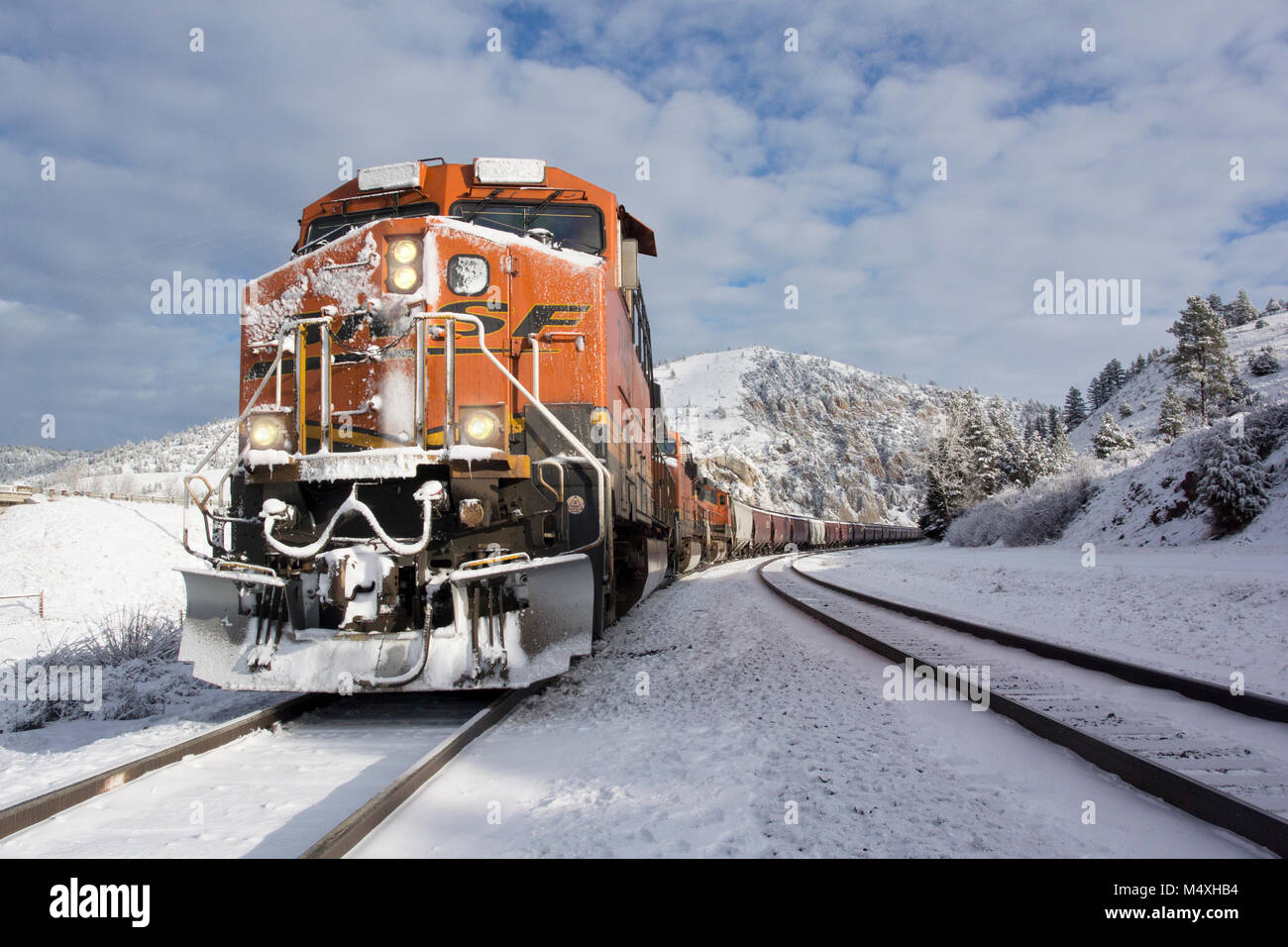 A BNSF train coming down the tracks in the snow on a cold, bright, sunny day. At Bearmouth, west ...