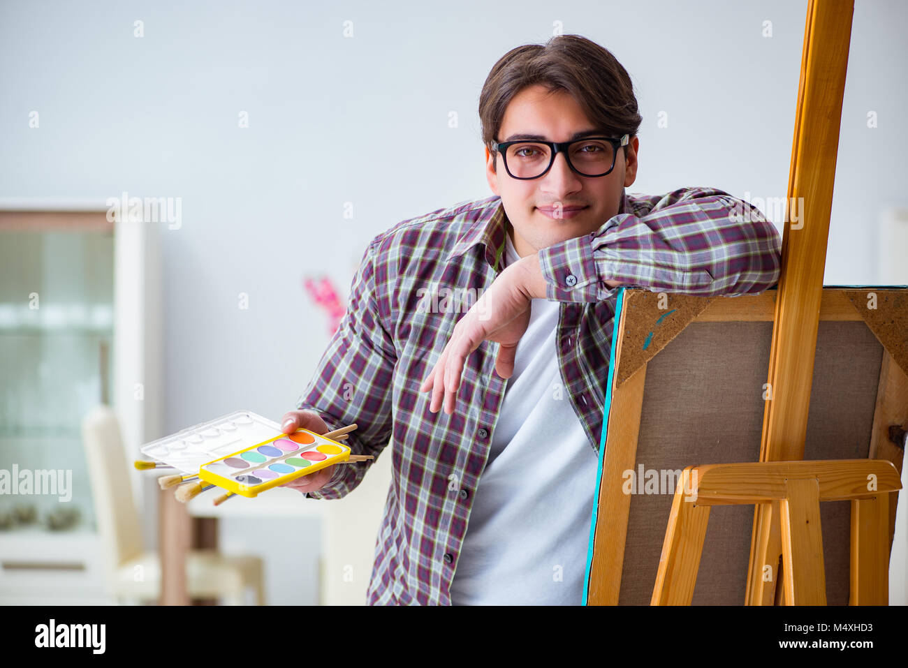 Young male artist drawing pictures in bright studio Stock Photo - Alamy
