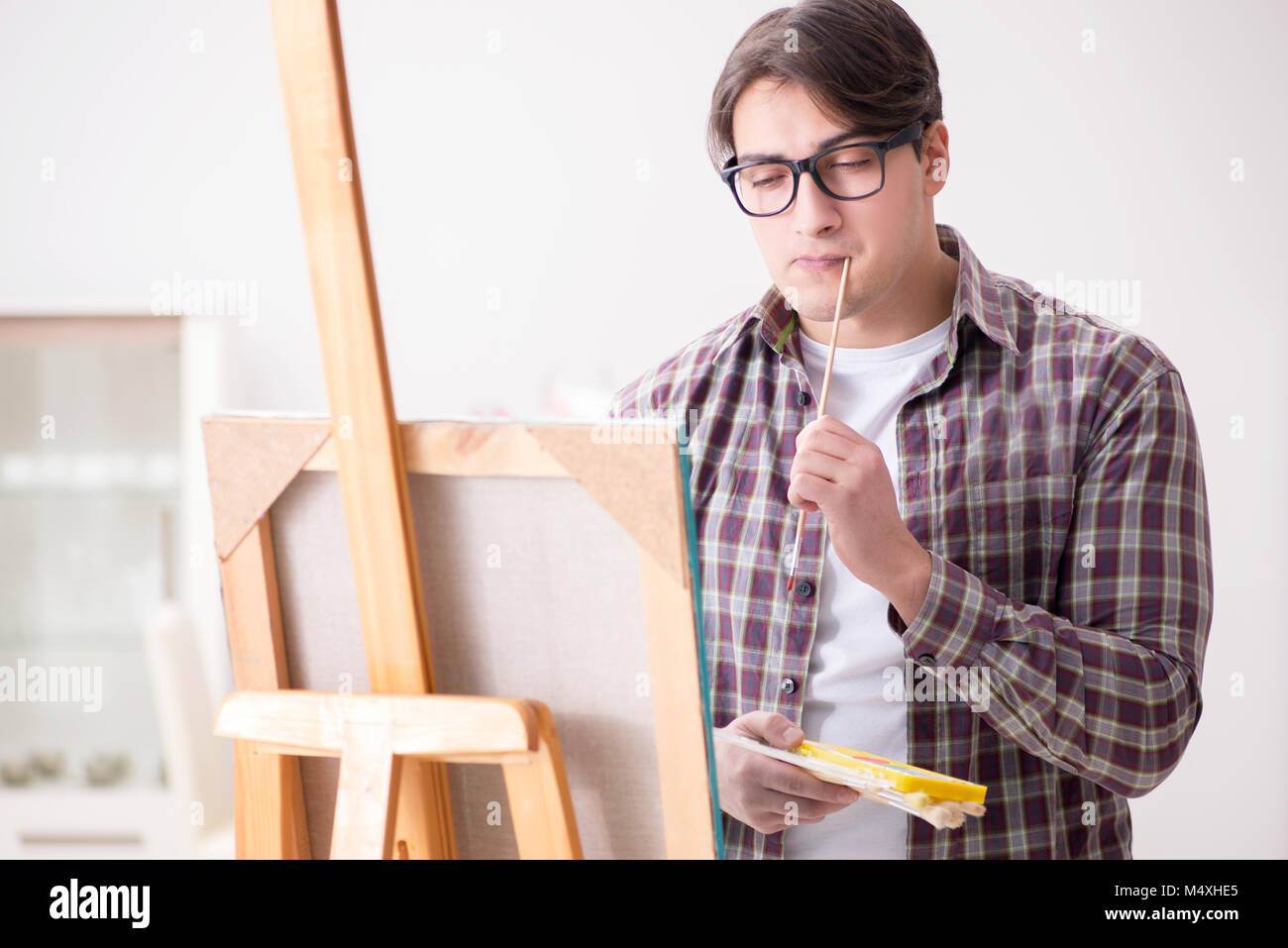 Young male artist drawing pictures in bright studio Stock Photo - Alamy