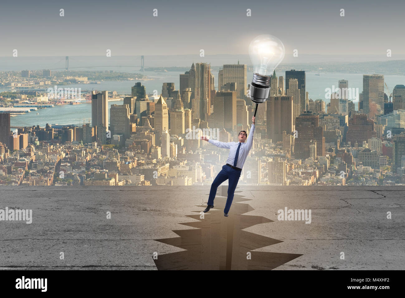 Businessman flying over gap on light bulb balloon Stock Photo - Alamy
