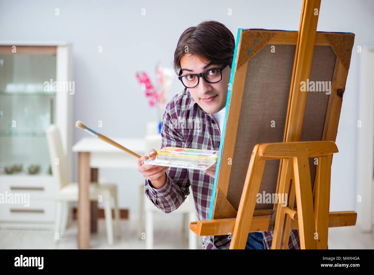 Young male artist drawing pictures in bright studio Stock Photo - Alamy