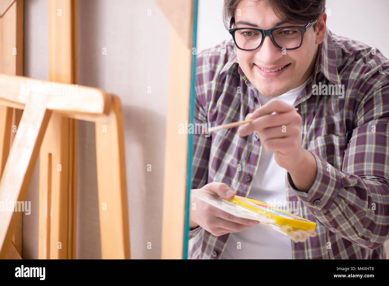 Young male artist drawing pictures in bright studio Stock Photo - Alamy