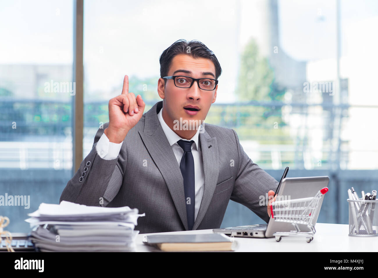 Businessman with shopping cart in office Stock Photo - Alamy