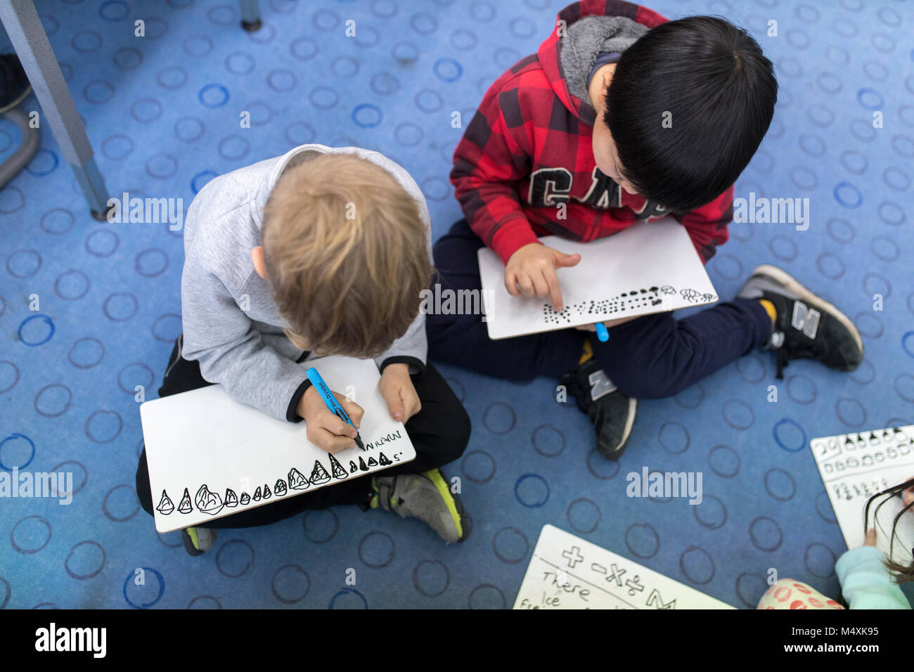 primary school children working in classroom Stock Photo - Alamy