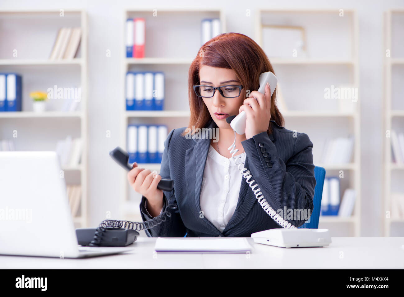 Frustrated call center assistant responding to calls Stock Photo - Alamy