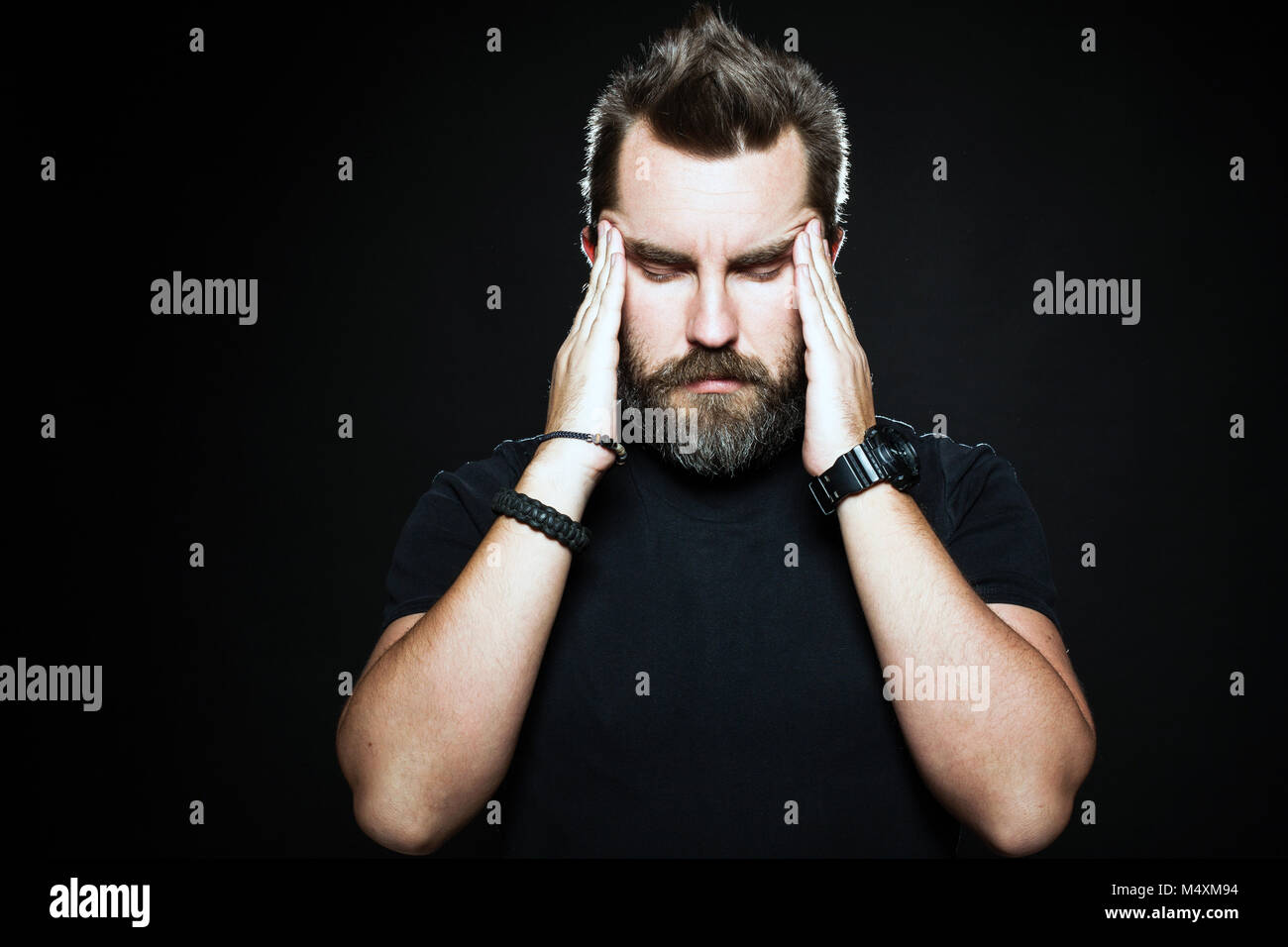 Terrible headache. Frustrated man touching head with hands and making ...