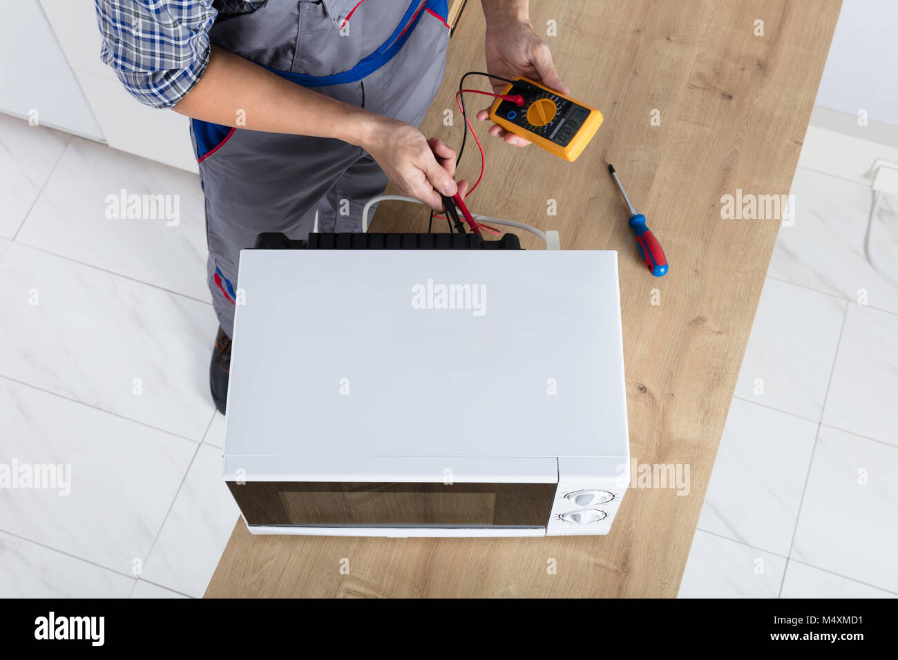Male Technician Checking Microwave Using Digital Multimeter Stock Photo ...