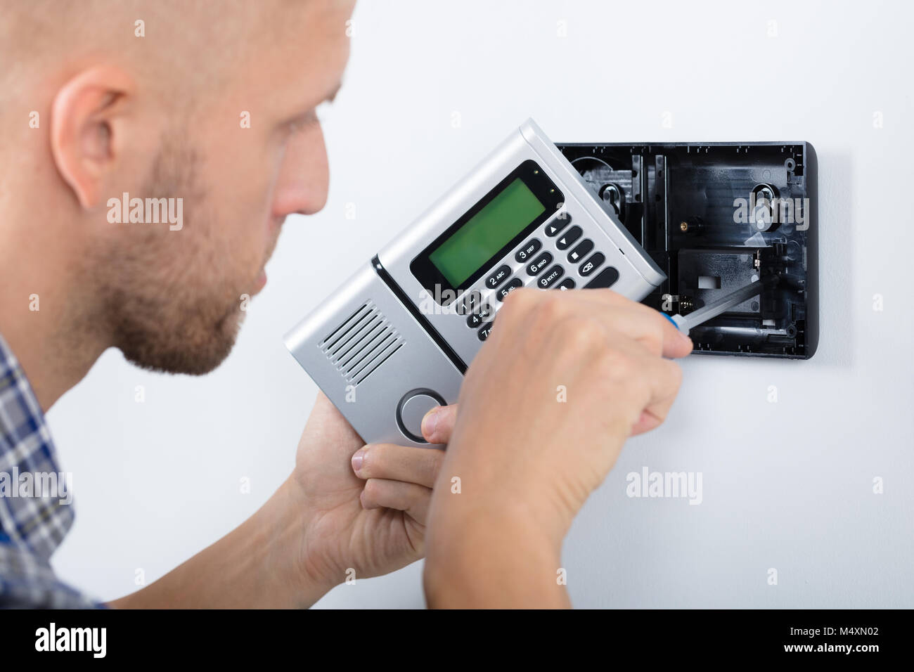 Young Male Technician Installing Security System Using Screwdriver ... Young Male Technician Installing Security System Using Screwdriver ...