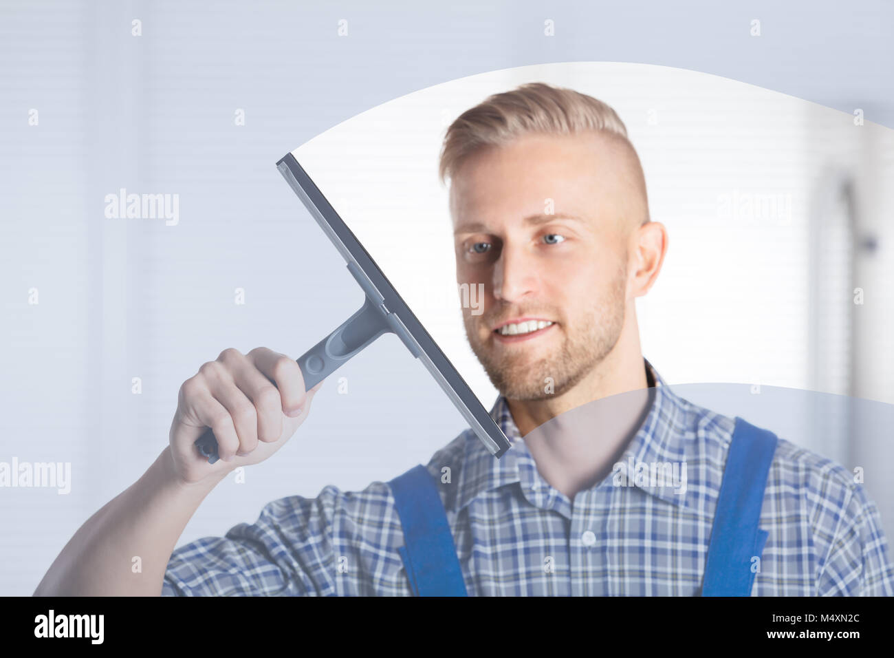 Smiling Young Worker Cleaning Glass Window With Squeegee In Kitchen ...